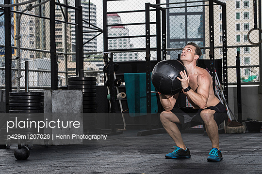 Man training with atlas ball at rooftop gym in Bangkok - Stock Image ...