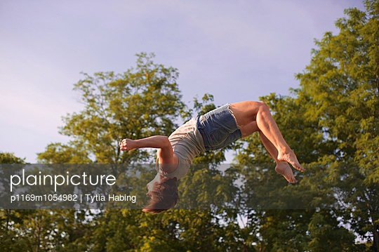 Woman flipping on trampoline - Stock Image - Everypixel
