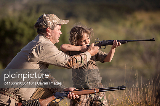 Father and daughter (6-7) hunting in field - Stock Image - Everypixel