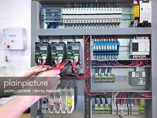 Hands of electrical engineer testing switch board in engineering ...