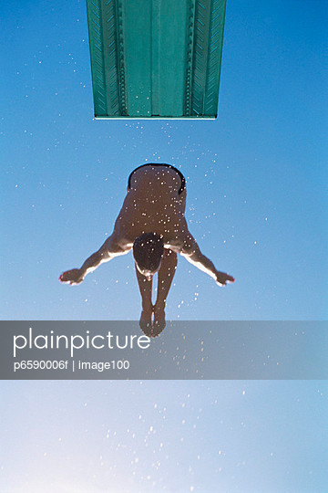 Low angle shot of a young man diving from a diving board - Stock Image ...