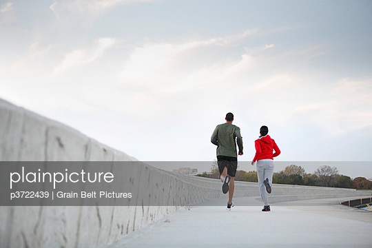 Young couple running near waterfront - Stock Image - Everypixel