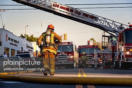 Fireman walking down the middle of street to his truck after battling ...