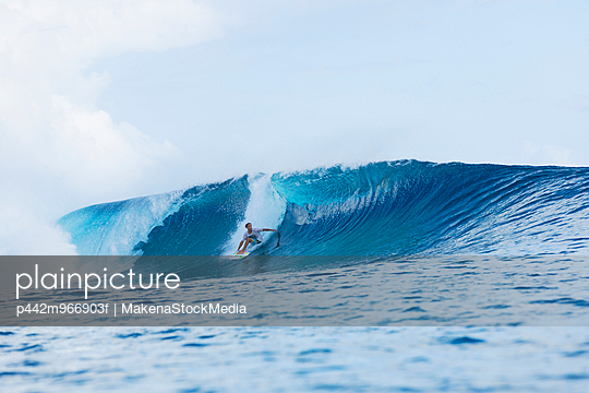 Surfer riding perfect waves in the South Pacific; Tahiti, French ...