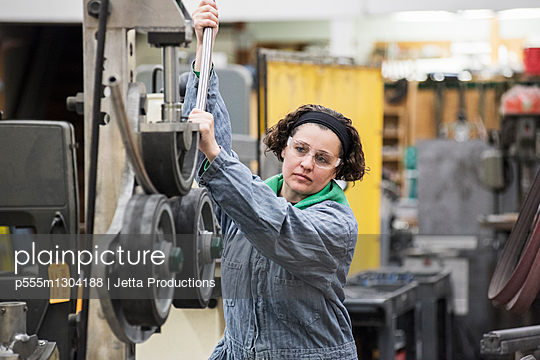Hispanic worker using machinery in factory - Stock Image - Everypixel