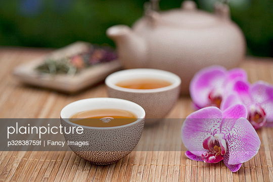 Orchids and a cup of tea - Stock Image - Everypixel