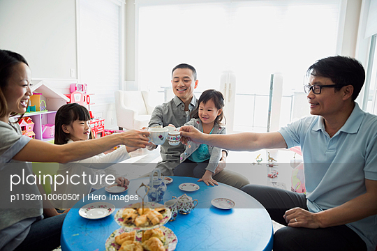 Multi-generation family toasting teacups in playroom - Stock Image ...