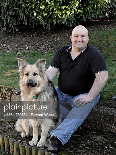 Happy Bald Middle Aged Man In Garden With Alsatian Dog, London, England ...