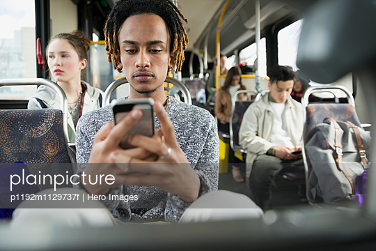 Young man texting with cell phone on bus - Stock Image - Everypixel