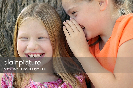 Two girls sharing secrets - Stock Image - Everypixel