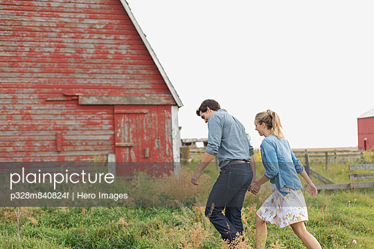 Young couple walking towards barn on rural property. - Stock Image ...
