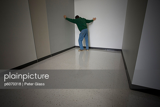 Man leaning against wall in lobby of office building - Stock Image ...