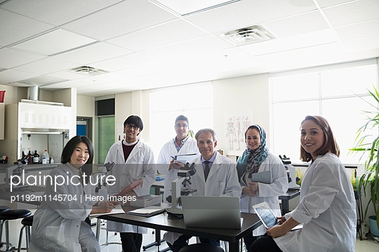 Portrait smiling professor and college students in science laboratory ...