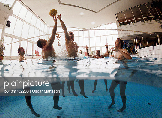 Playing volley ball in a swimming pool - Stock Image - Everypixel