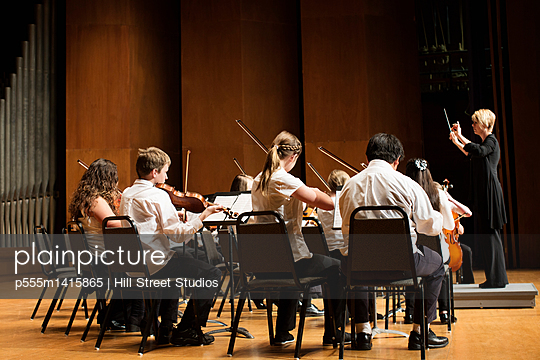 Student orchestra playing on stage - Stock Image - Everypixel