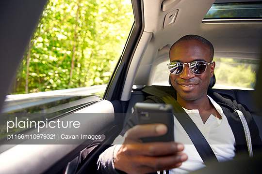 Man traveling by car and using smart phone - Stock Image - Everypixel