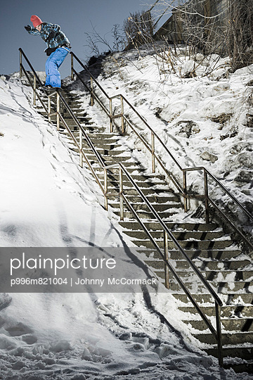 Snowboarder slides a large hand rail - Stock Image - Everypixel