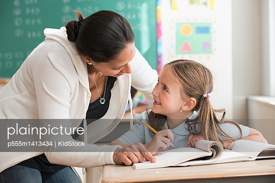Teacher helping student in classroom - Stock Image - Everypixel