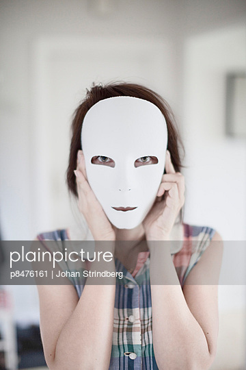 A young woman in black holding a white mask over his face - Stock Image ...