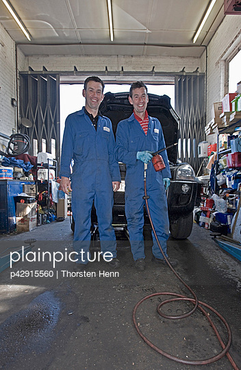 Mechanics smiling in auto repair shop - Stock Image - Everypixel