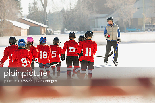 Coach with hockey team playing on ice rink - Stock Image - Everypixel